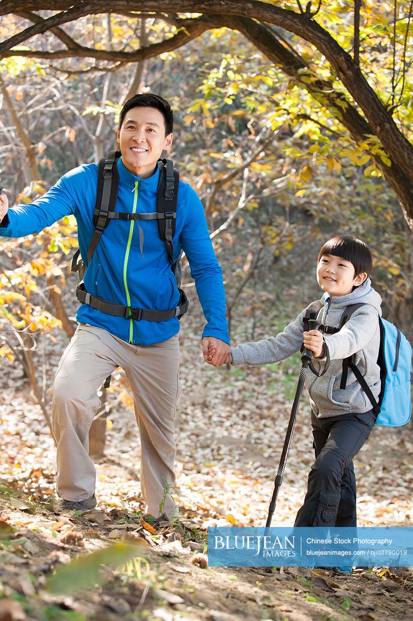 Cheerful Chinese father and son hiking-High-res stock photo for download
