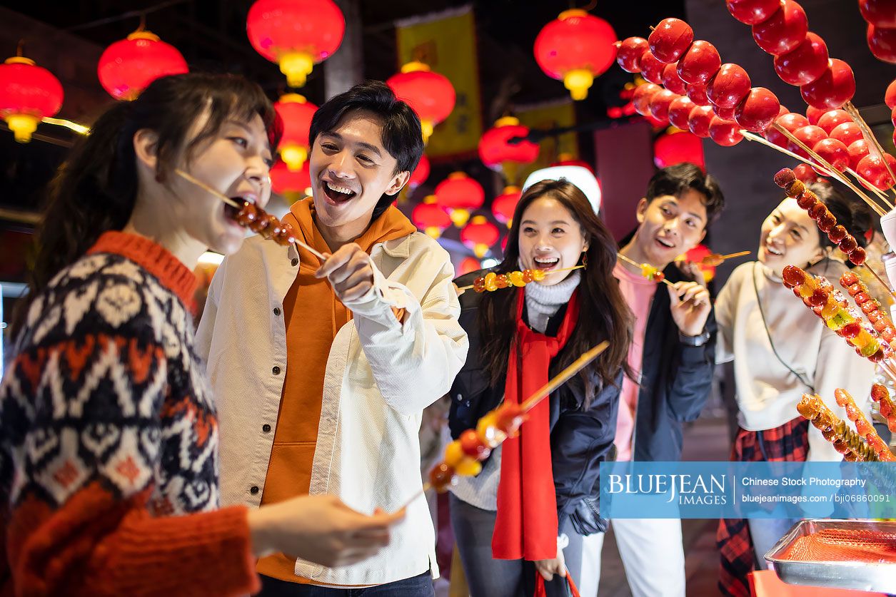 Young Chinese friends with candied haw celebrating Chinese New Year ...