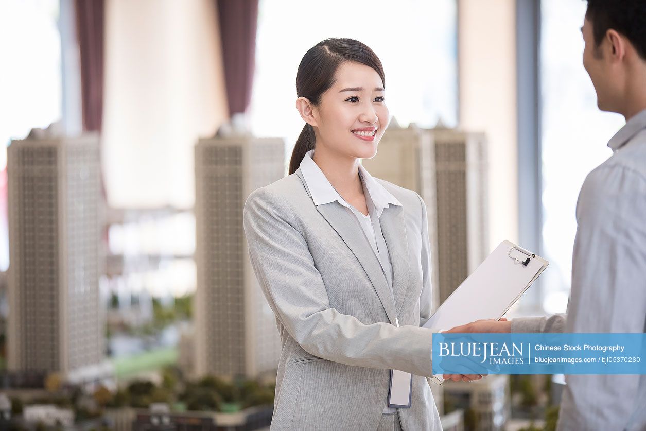 Confident Chinese realtor shaking hands with customer-High-res stock ...