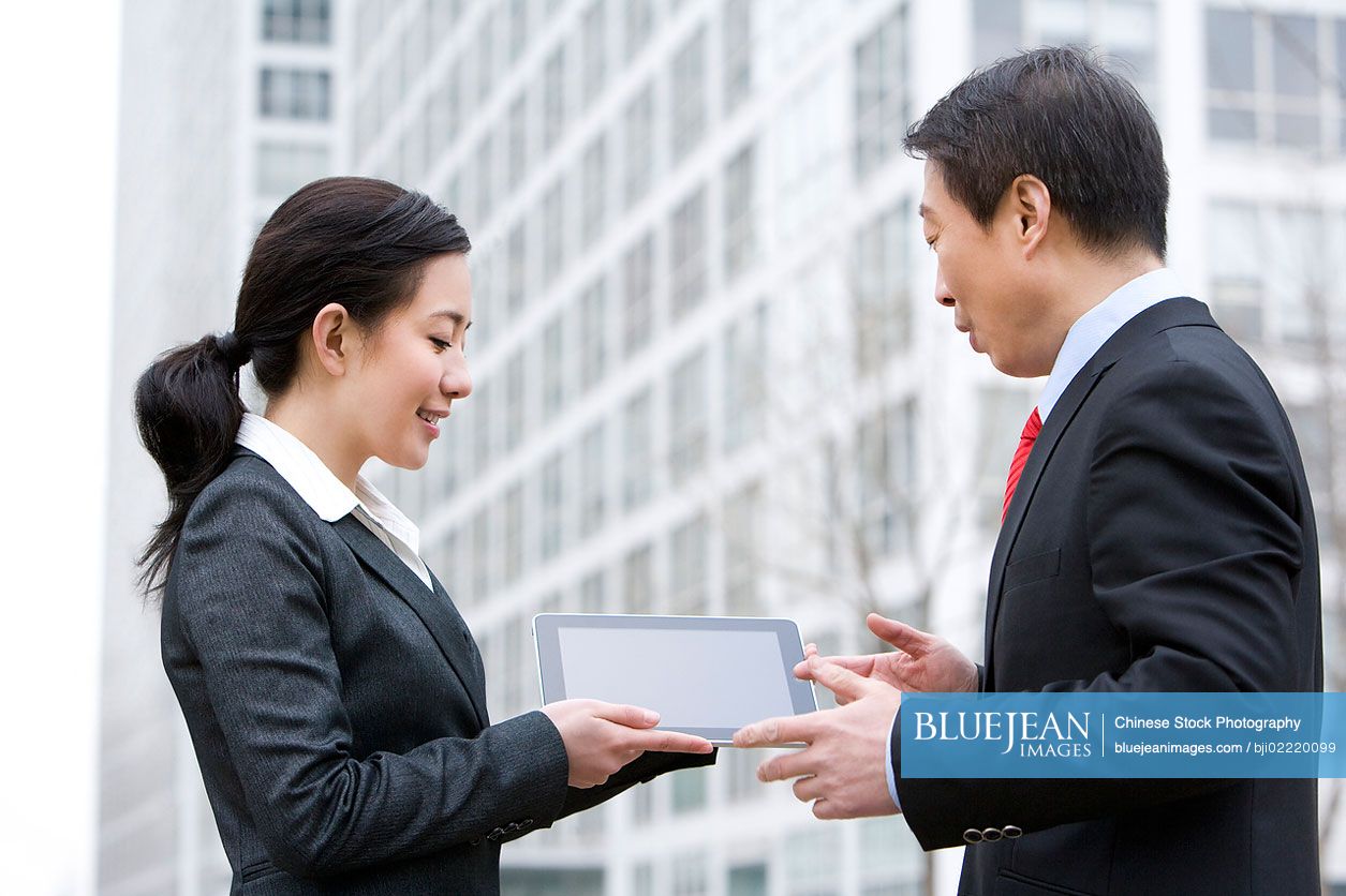 Chinese business partners using a digial tablet together-High-res stock ...