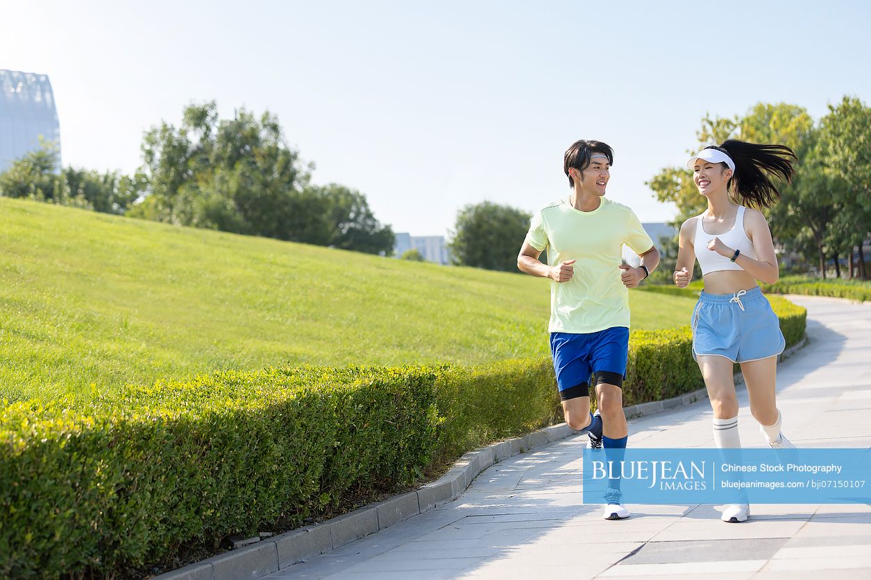 Happy young Chinese couple jogging outdoors-High-res stock photo for ...
