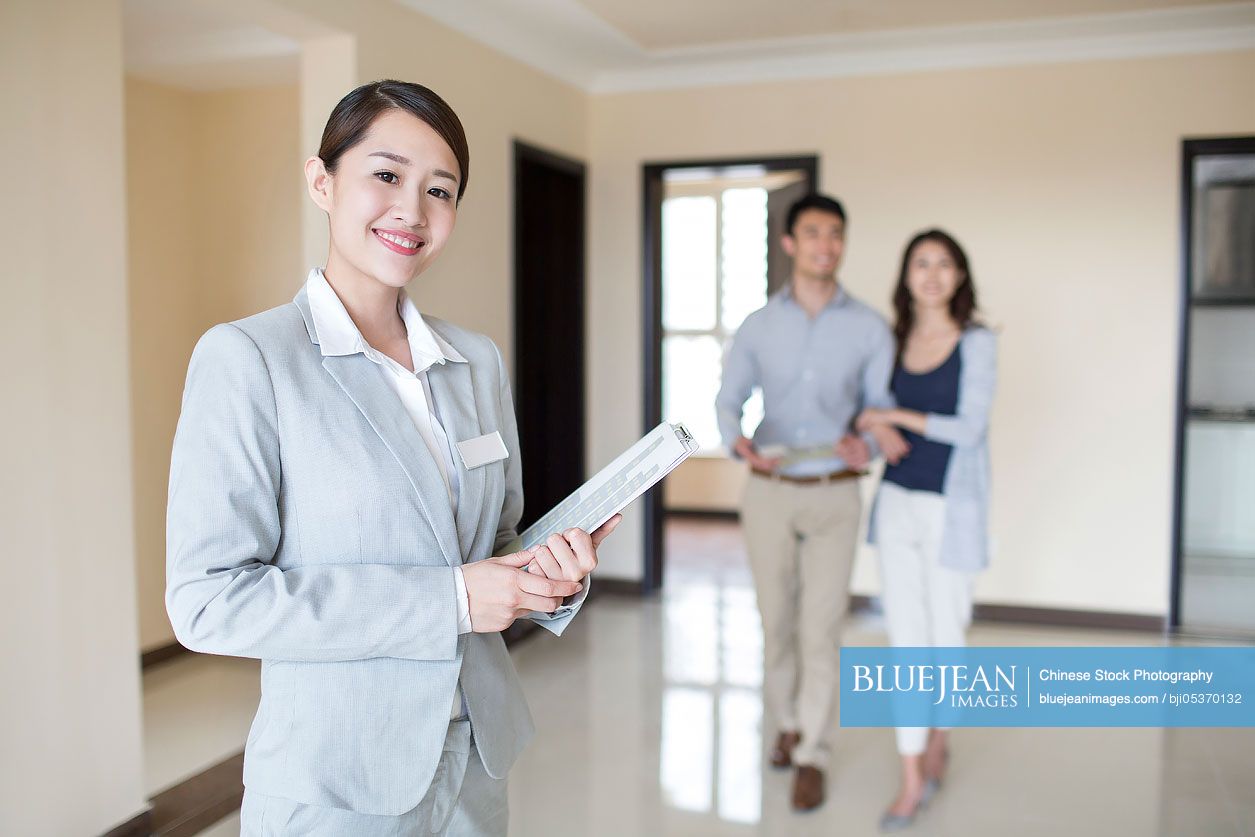 Chinese realtor showing new house to young couple-High-res stock photo for download