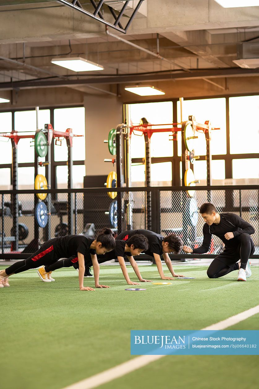 Active Chinese children having exercise class with their coach in gym-High-res stock photo for ...