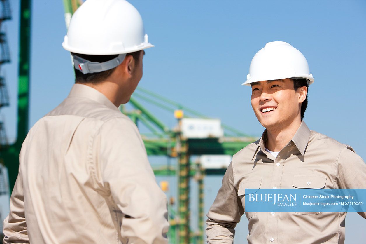 Male Chinese shipping industry workers talking-High-res stock photo for ...