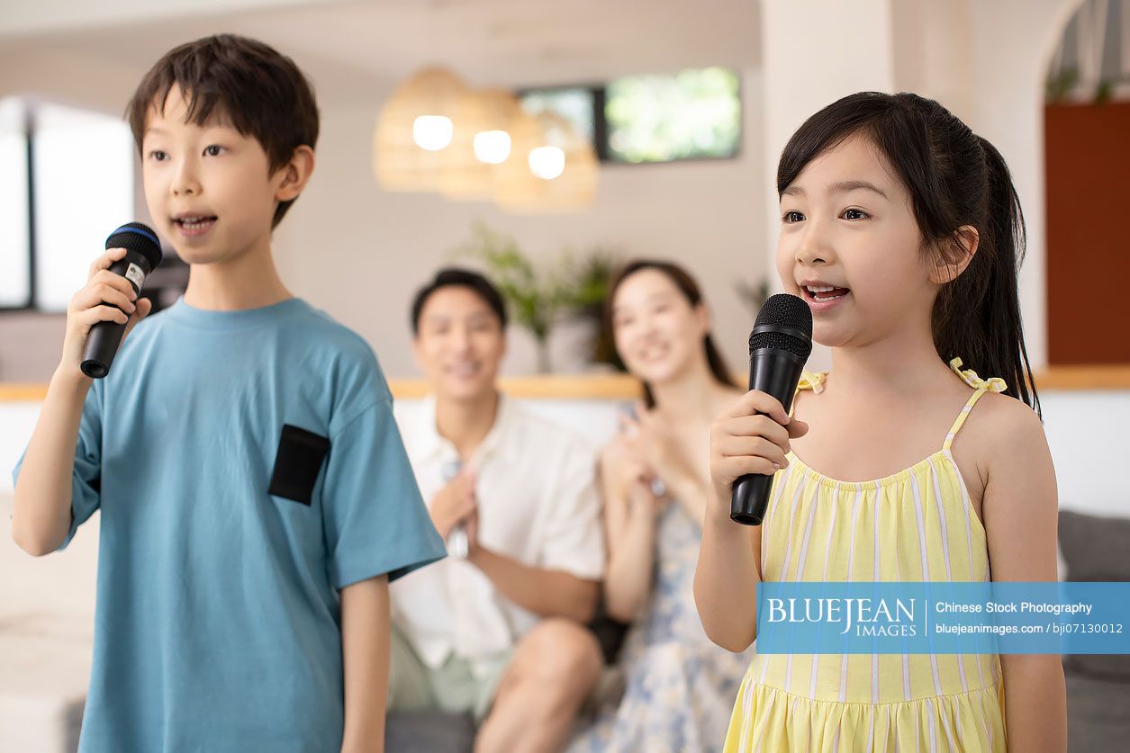 Happy Chinese family singing with microphones at home-High-res stock ...