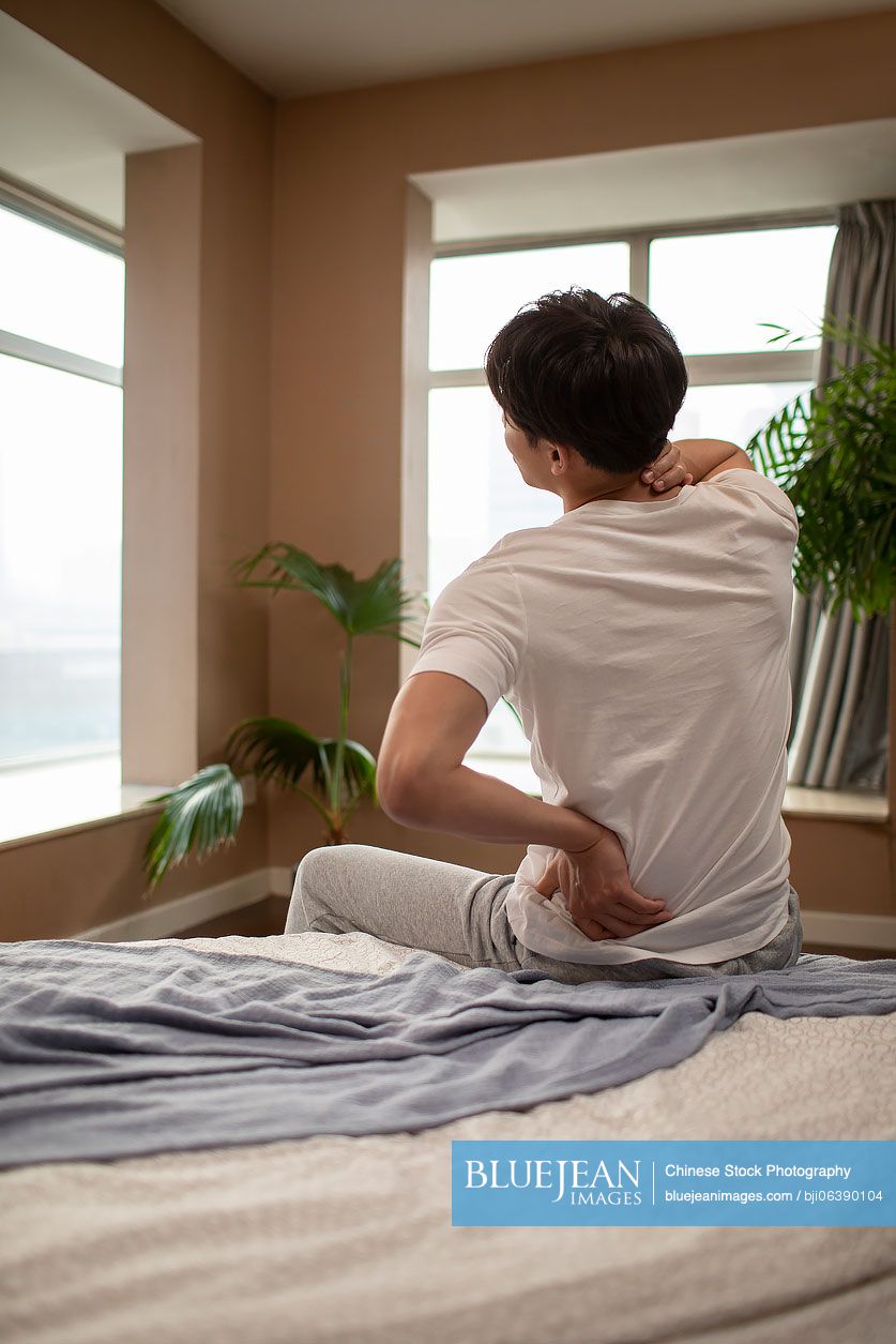 Young Chinese man with back and neck pain-High-res stock photo for download