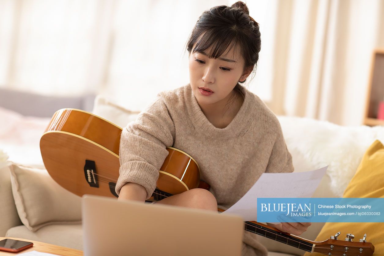 Young Chinese woman writing music at home-High-res stock photo for download