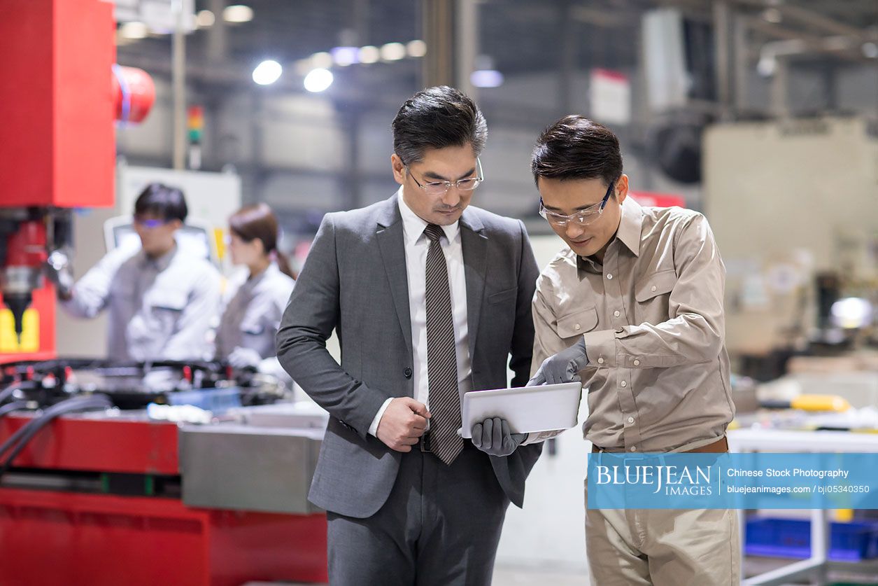Chinese businessman and engineer talking in the factory-High-res stock ...