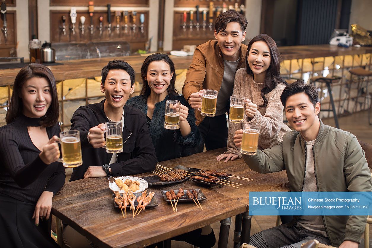Happy Chinese friends toasting and cheering in bar-High-res stock photo ...