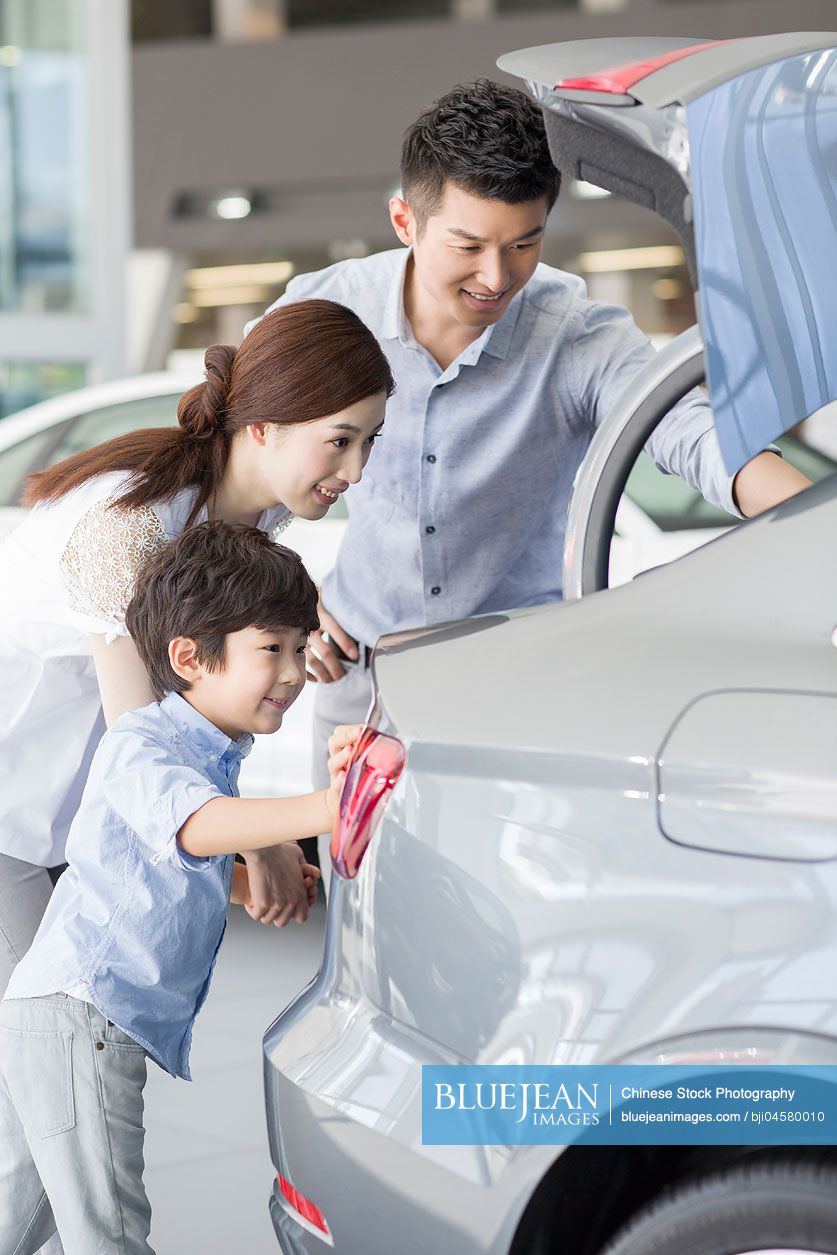 Young Chinese family looking at new car in showroom-High-res stock ...