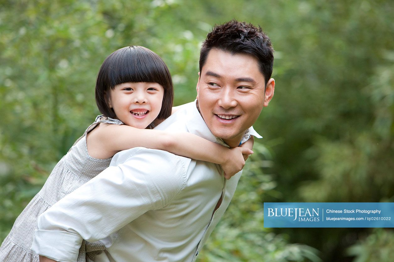 Chinese father and daughter having fun in garden-High-res stock photo for download