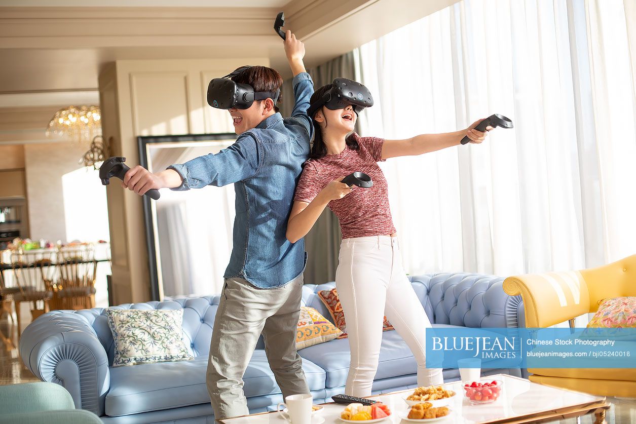 Young Chinese couple playing VR game-High-res stock photo for download