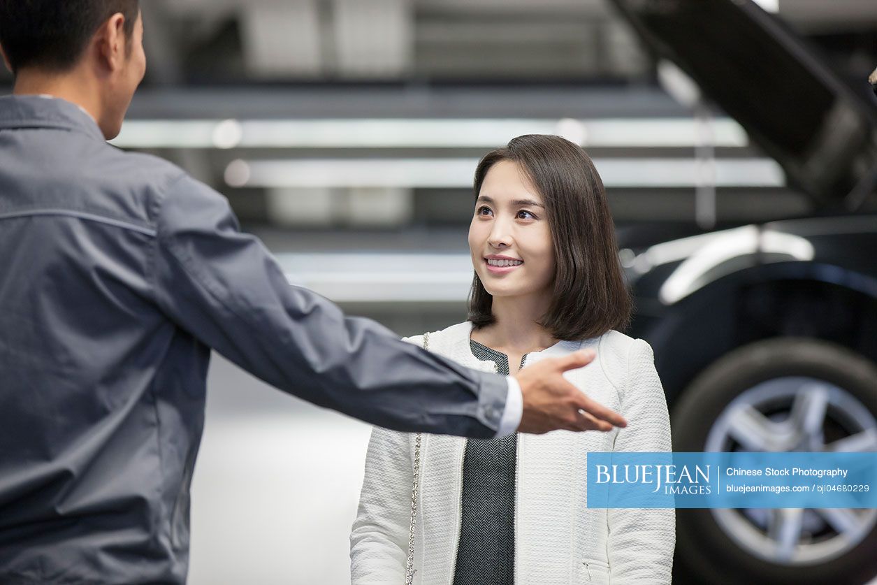 Chinese auto mechanic talking with car owner-High-res stock photo for ...