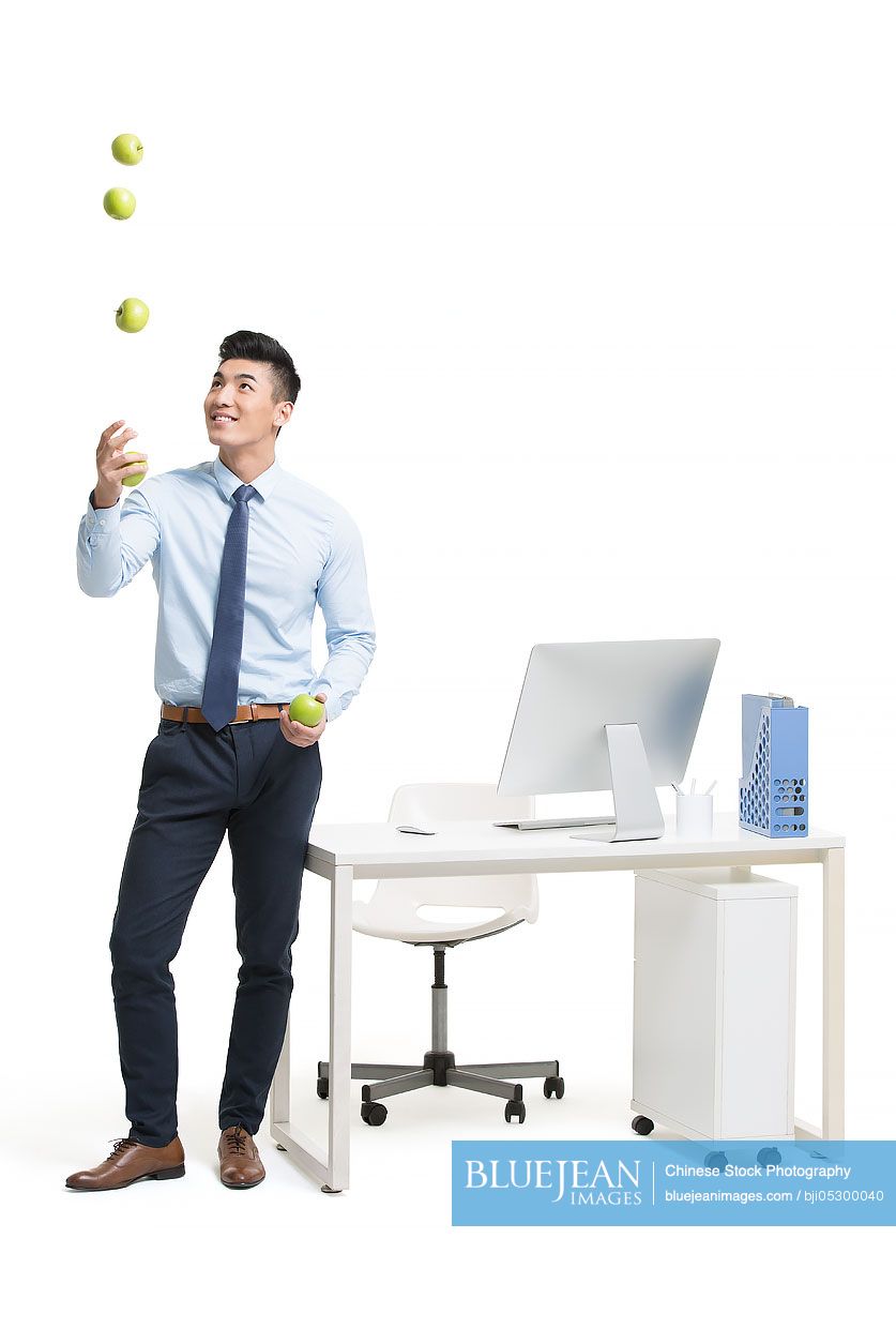 Young Chinese Businessman In Office Juggling Apples High res Stock young-chinese-businessman-in-office-juggling-apples-high-res-stock