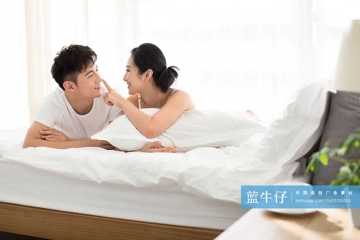 快乐的年轻情侣趴在床上 蓝牛仔影像 中国原创广告影像素材