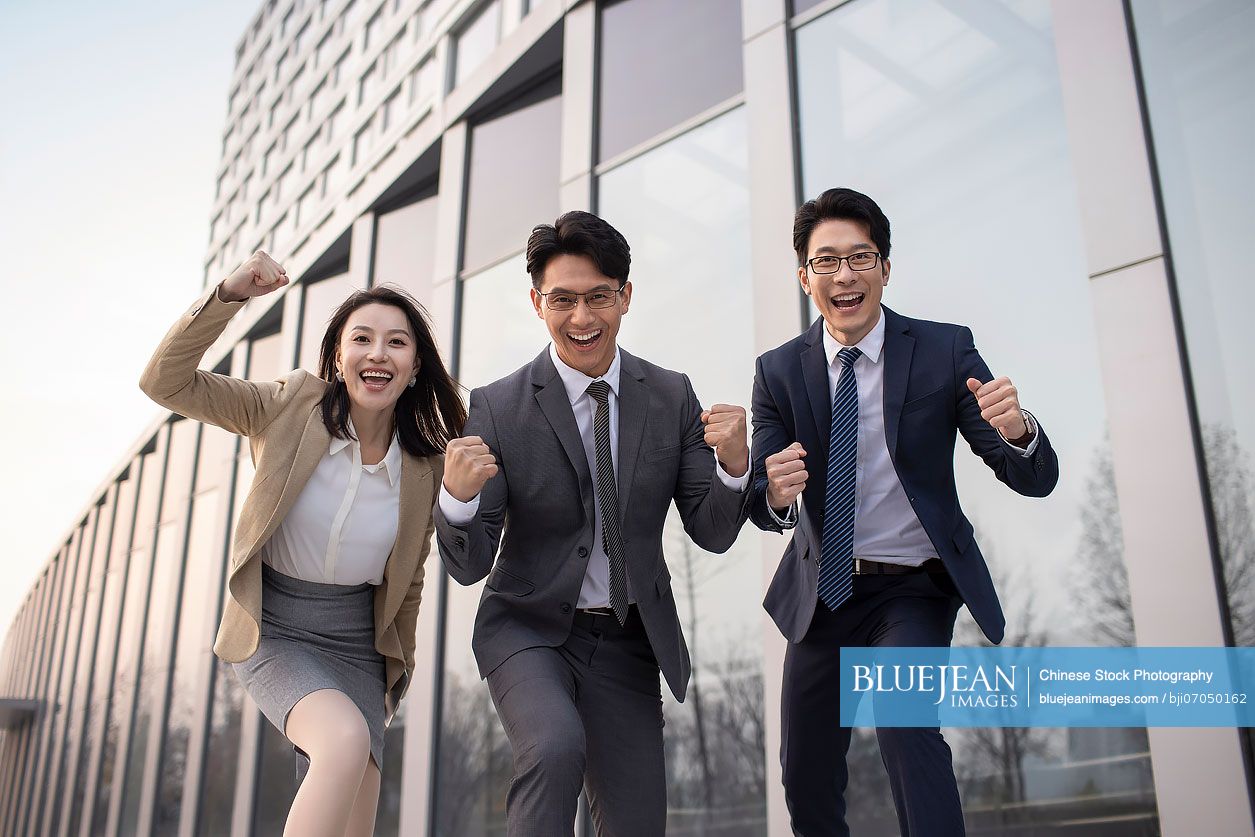 Successful Chinese business people punching the air outdoors-High-res ...