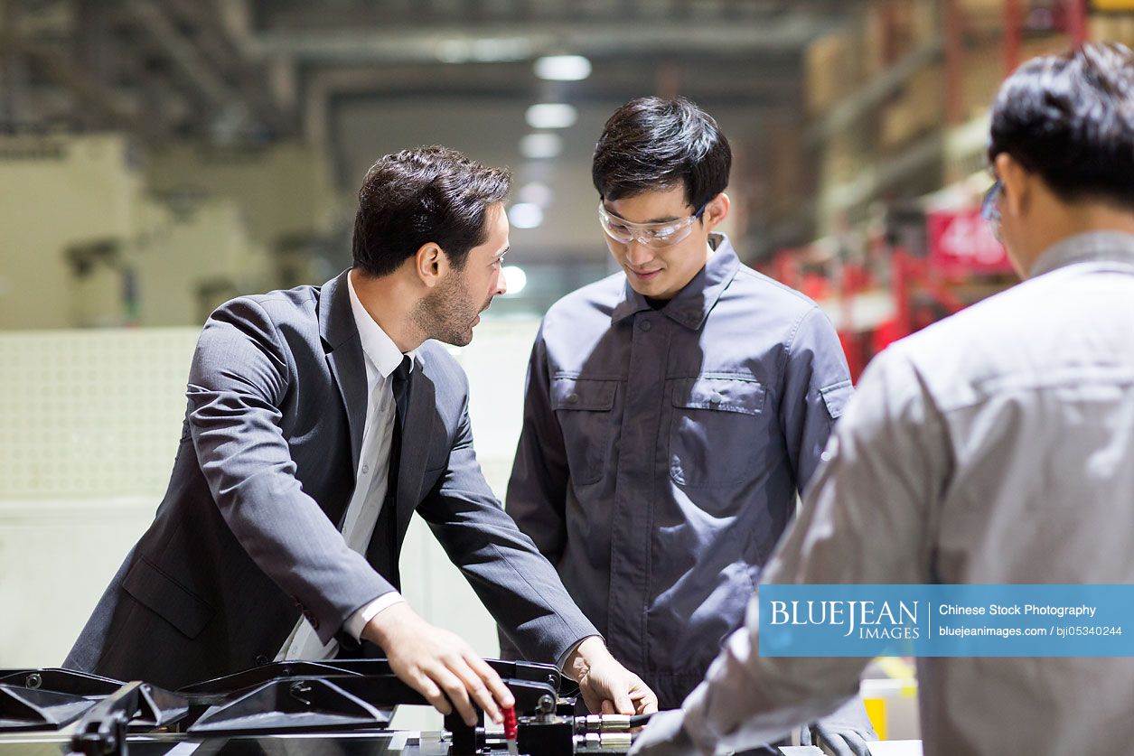 Businessman and engineers checking machine in the factory-High-res ...