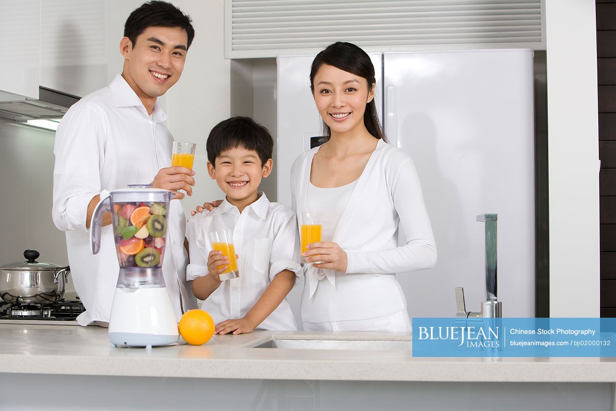 Chinese family drinking fresh orange juice in kitchen-High-res stock ...