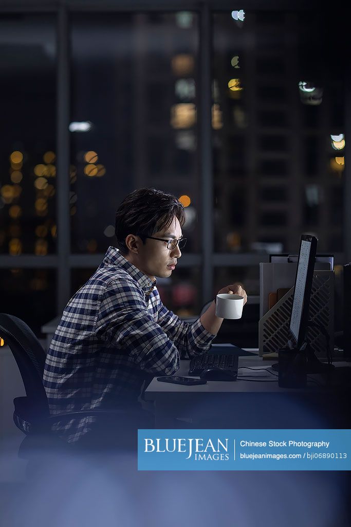 Chinese IT worker working in office at night-High-res stock photo for ...