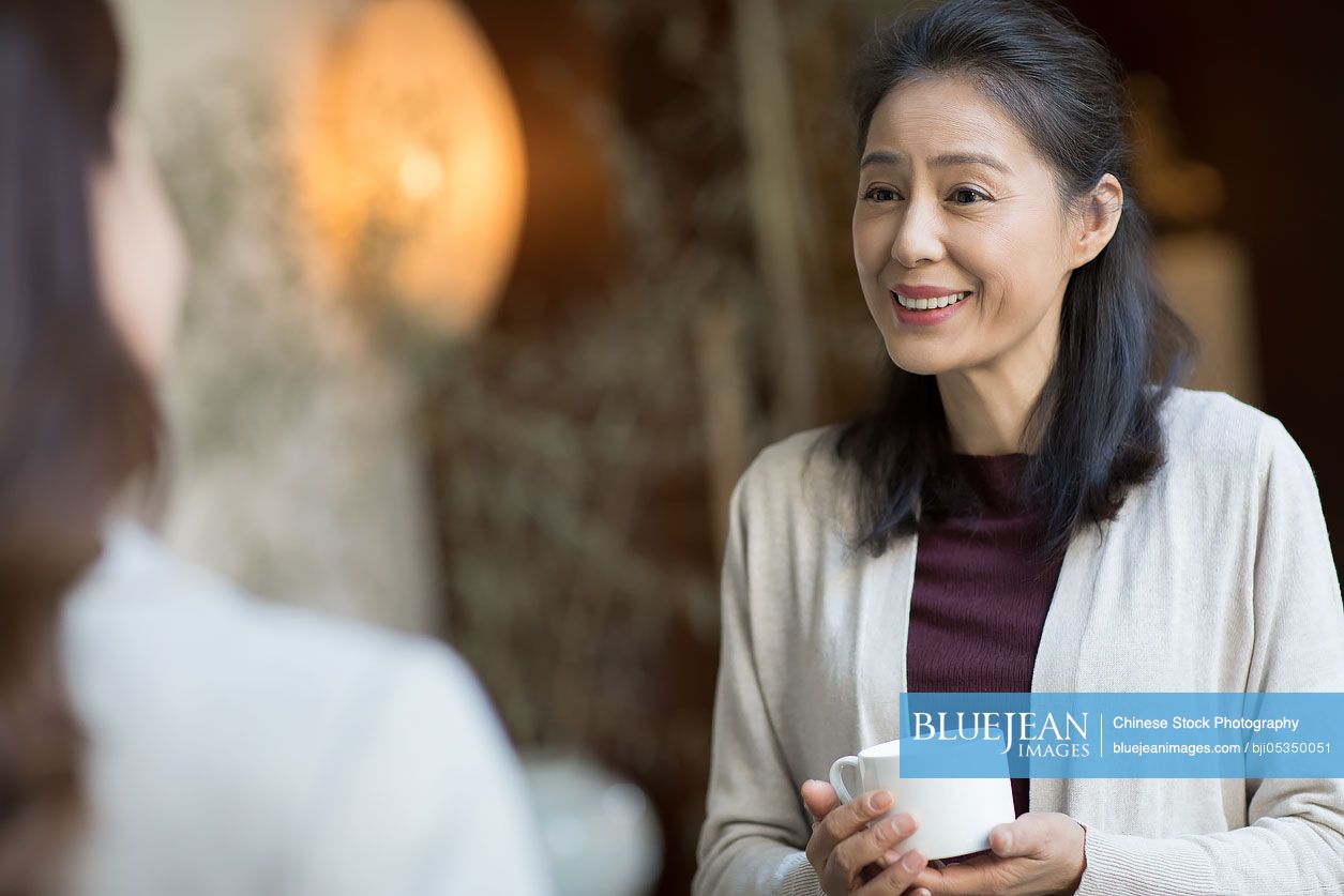 Elegant mature Chinese woman talking with young woman-High-res stock ...