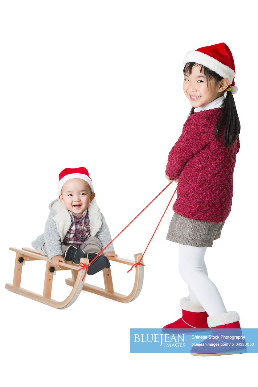 Chinese sister and brother playing with sled-High-res stock photo for download