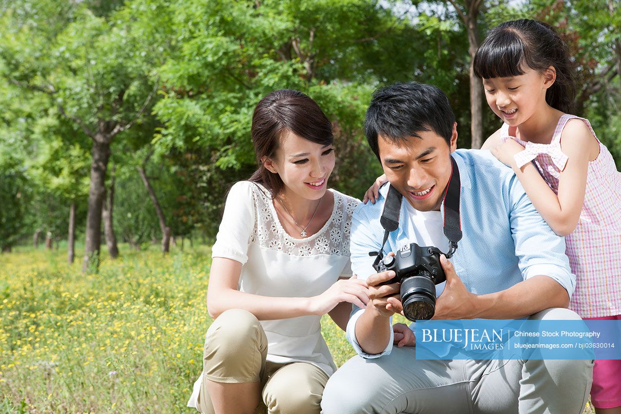 Happy Chinese family checking photos in SLR camera-High-res stock photo ...