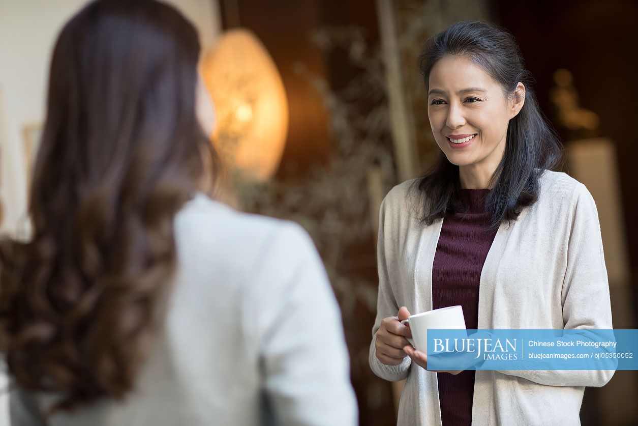 Elegant mature Chinese woman talking with young woman-High-res stock ...
