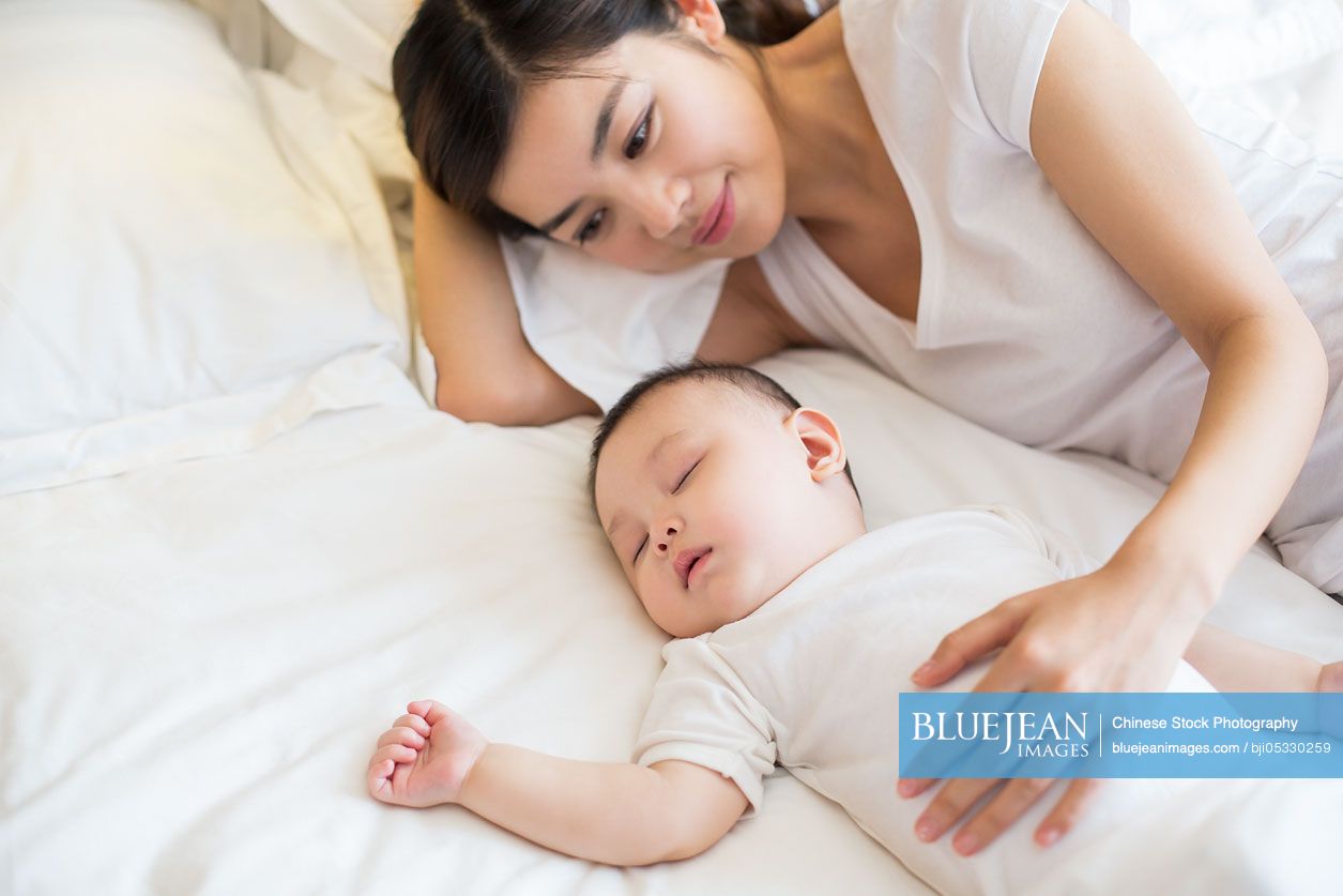 Young Chinese mother with sleeping baby boy-High-res stock photo for ...