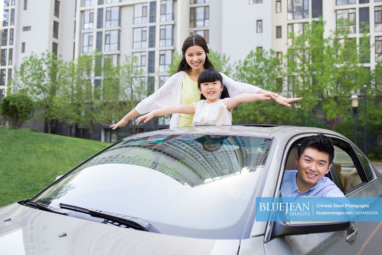 Happy young Chinese family in a car-High-res stock photo for download