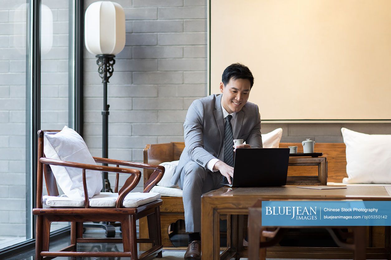 Cheerful Chinese businessman using laptop-High-res stock photo for download