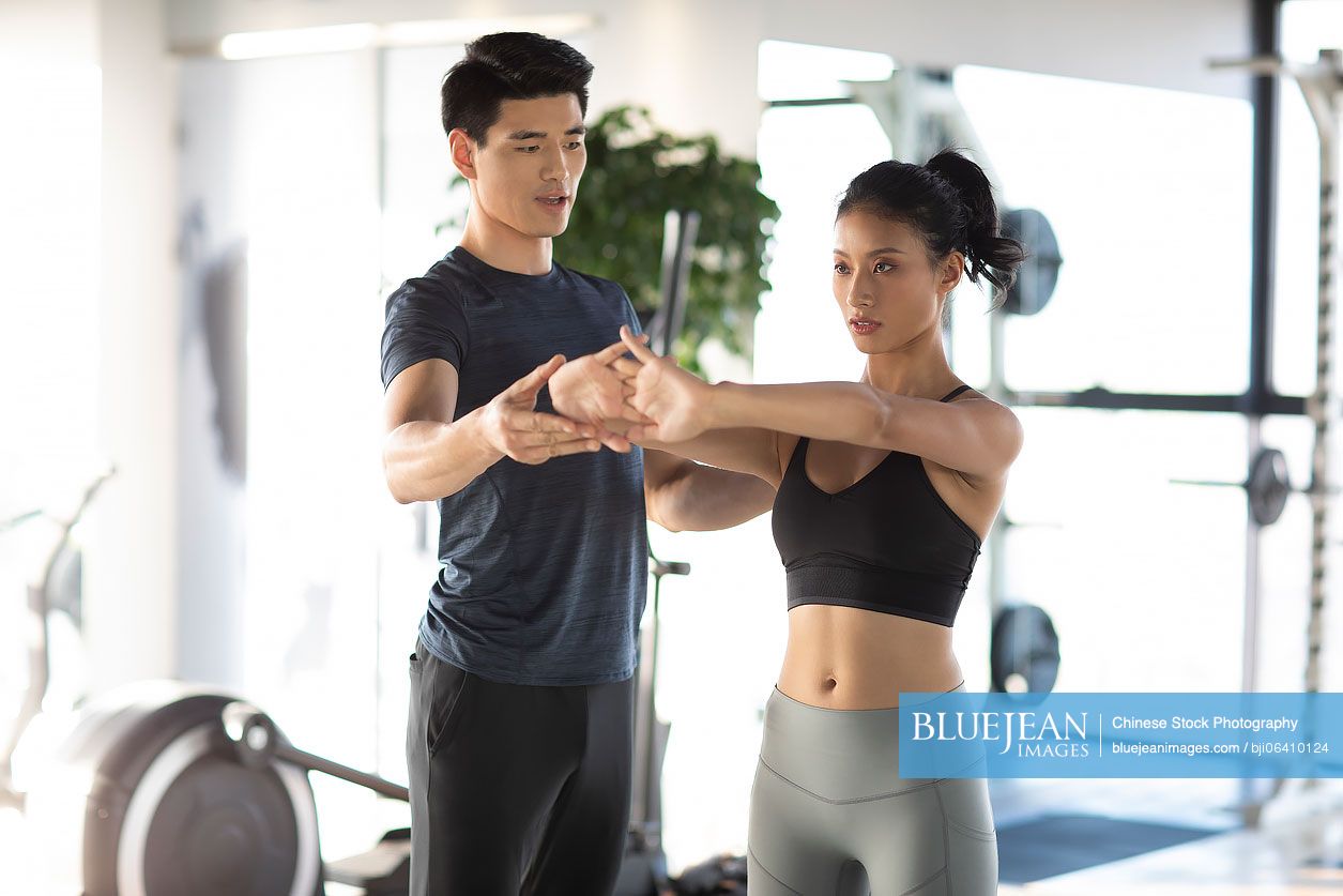 Young Chinese woman working out with personal trainer at gym-High-res ...