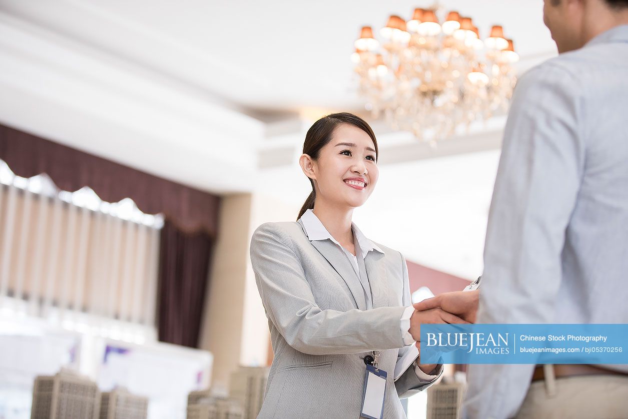 Confident Chinese realtor shaking hands with customer-High-res stock ...