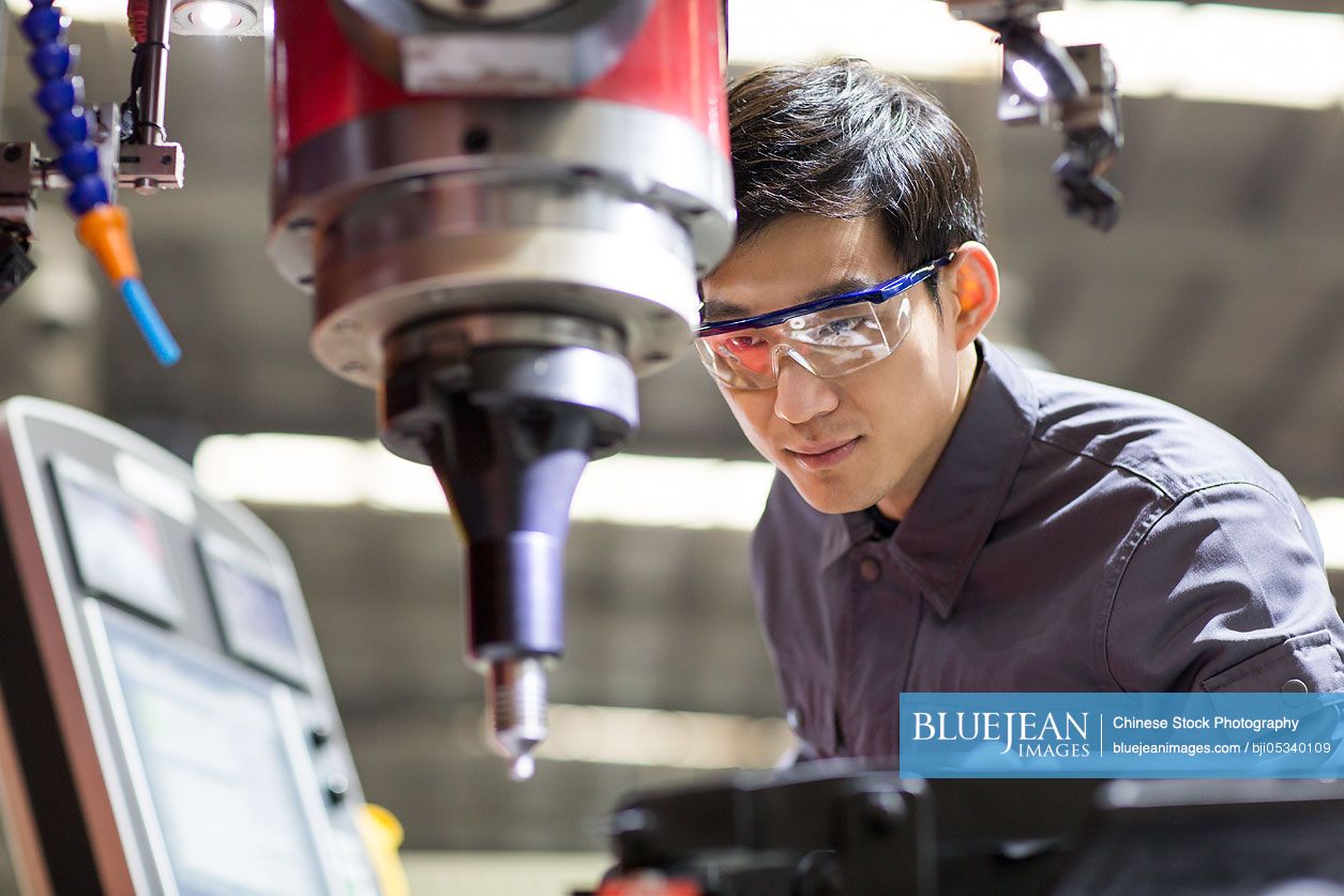 Young Chinese engineer working in the factory-High-res stock photo for ...