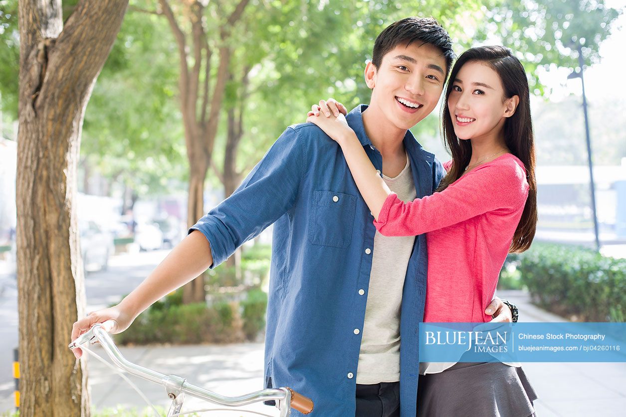 Young Chinese couple dating at campus with bicycle-High-res stock photo ...