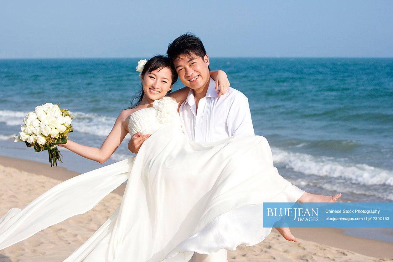 Happy Chinese newlyweds on the beach-High-res stock photo for download