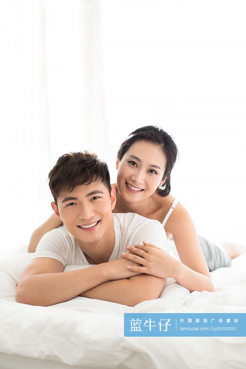 快乐的年轻情侣趴在床上 蓝牛仔影像 中国原创广告影像素材