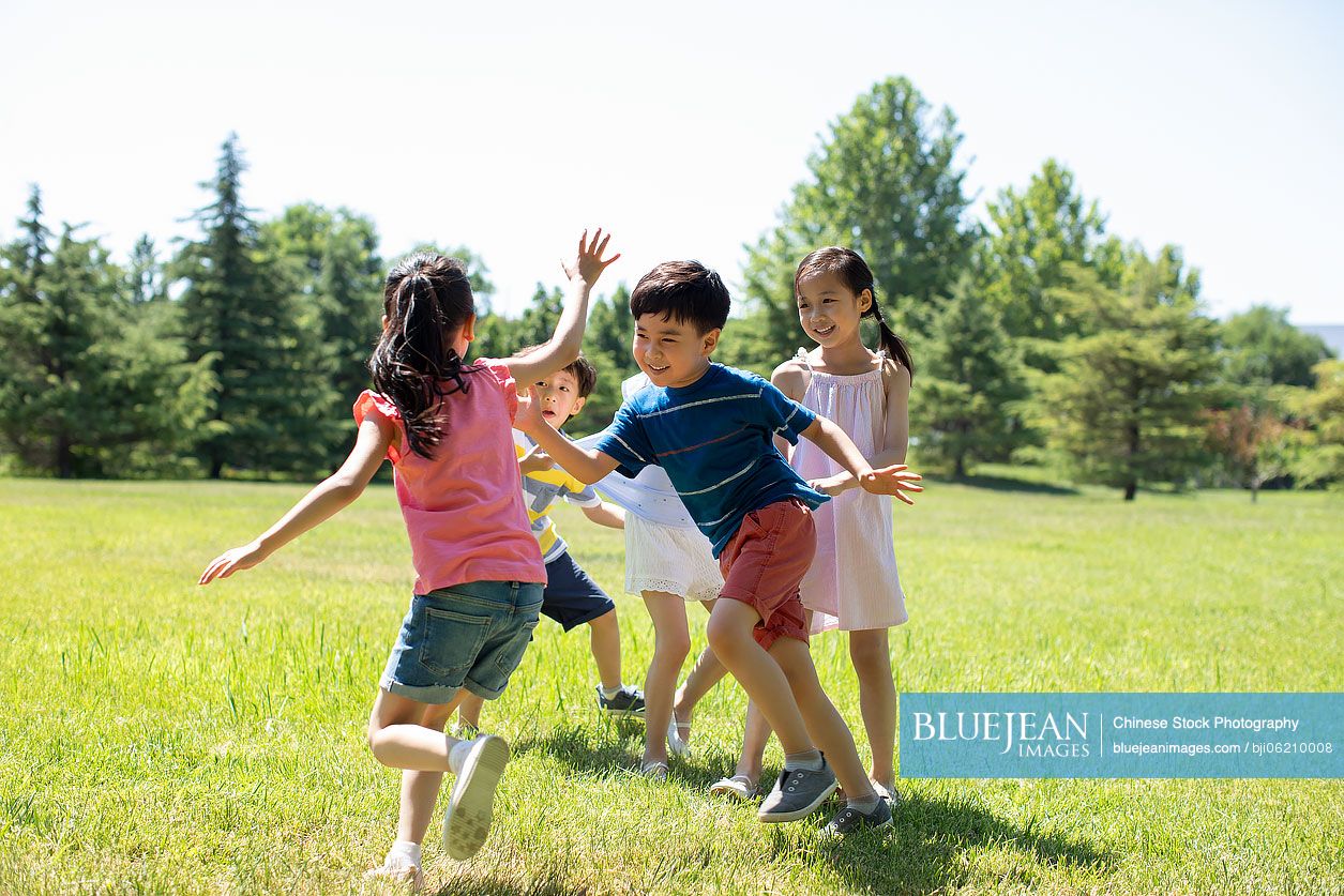 Happy Chinese children playing games on meadow-High-res stock photo for ...