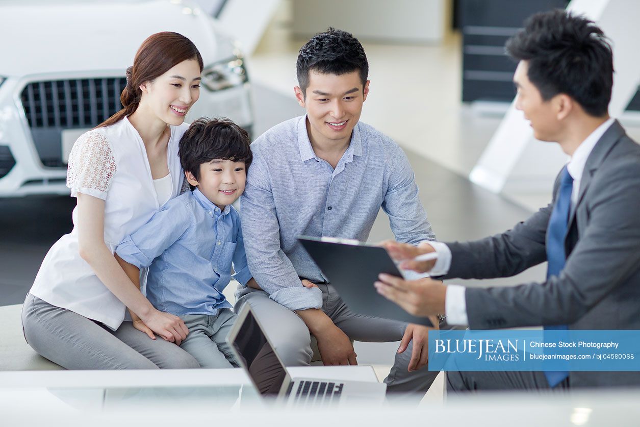 Young Chinese family buying car in showroom-High-res stock photo for ...