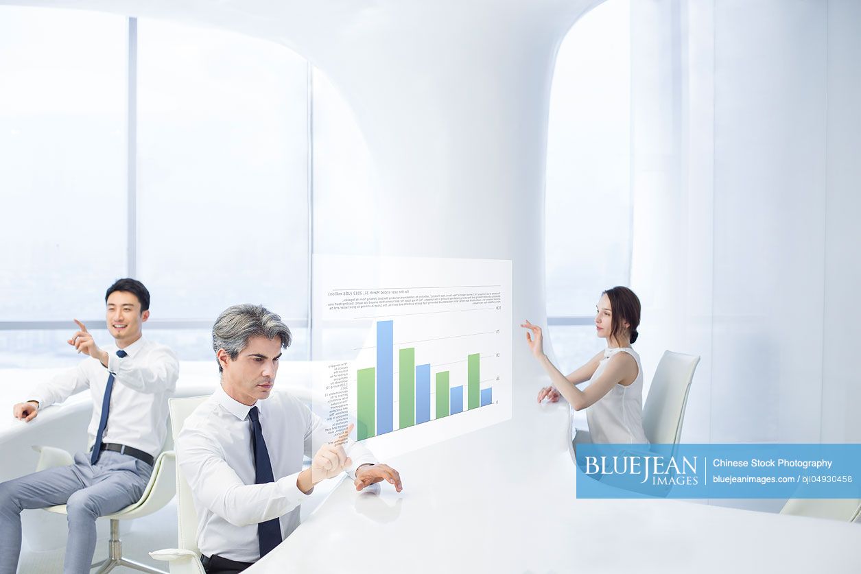 Business people using advanced touch screen technology in office-High ...