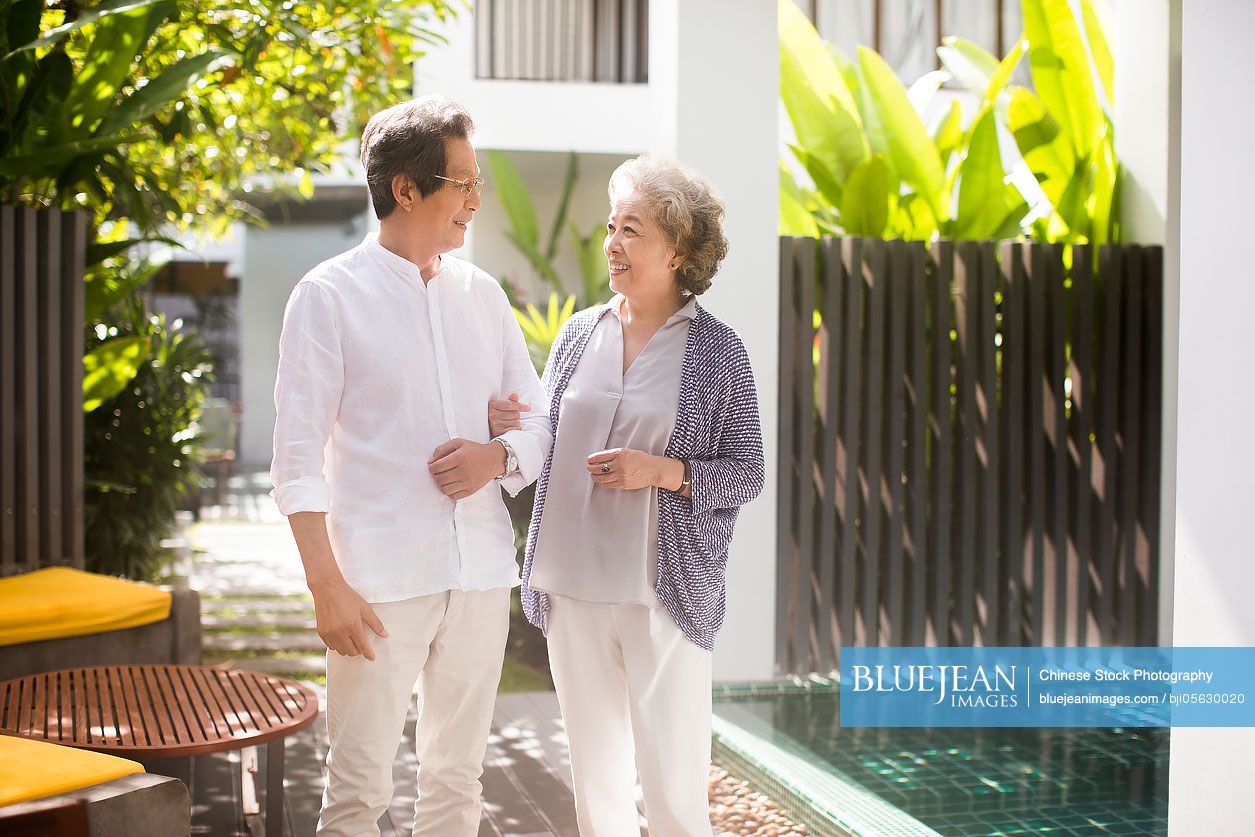 Happy senior Chinese couple strolling and talking-High-res stock photo for download