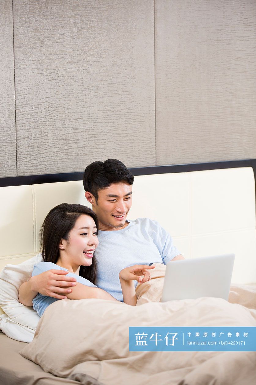 年轻夫妇在床上使用笔记本电脑 蓝牛仔影像 中国原创广告影像素材