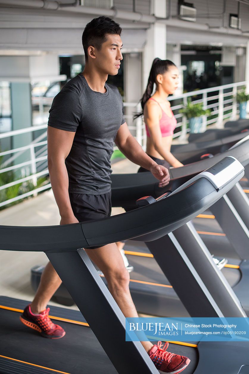 Young Chinese man exercising on treadmill in gym-High-res stock photo ...