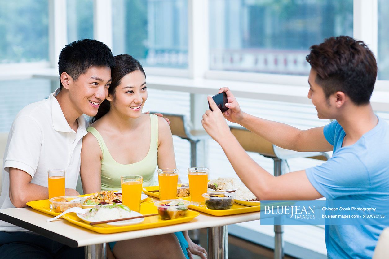 Young Chinese adults photographing in restaurant-High-res stock photo ...