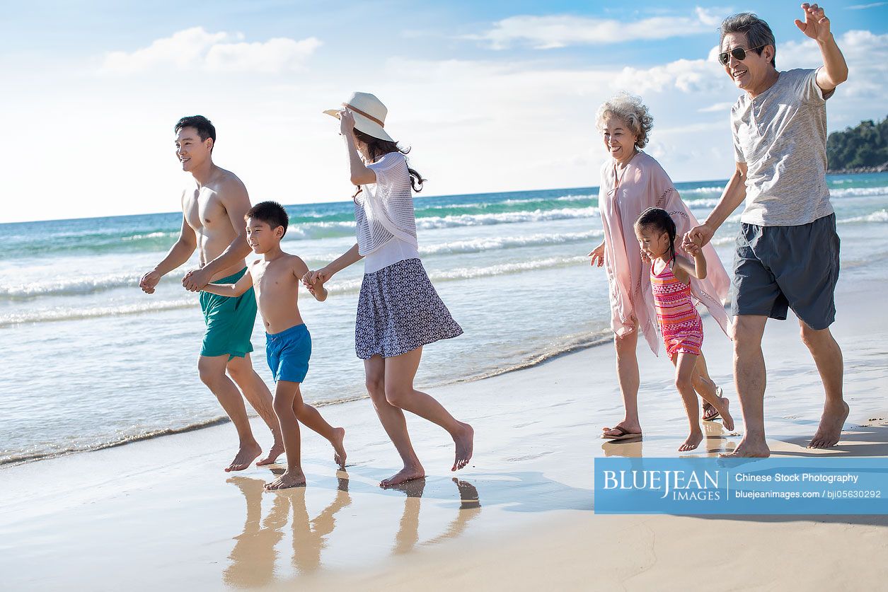 Happy Chinese family running on beach-High-res stock photo for download