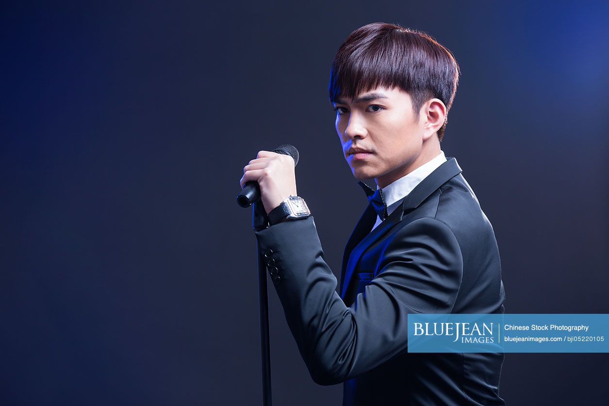 Young Chinese man singing with microphone-High-res stock photo for download