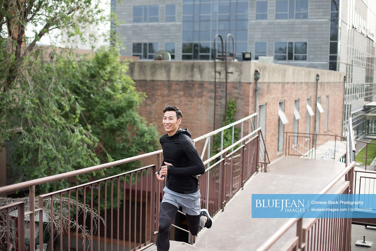 Young Chinese man jogging outdoors-High-res stock photo for download