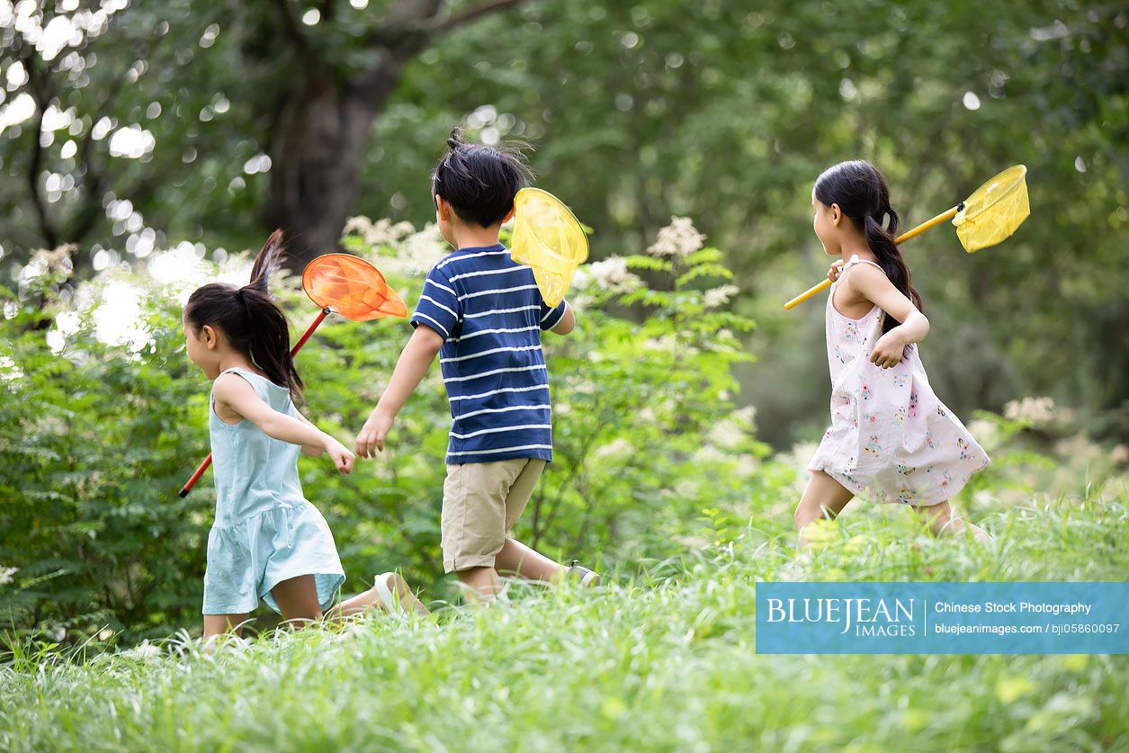 Three Chinese children playing on grass-High-res stock photo for download