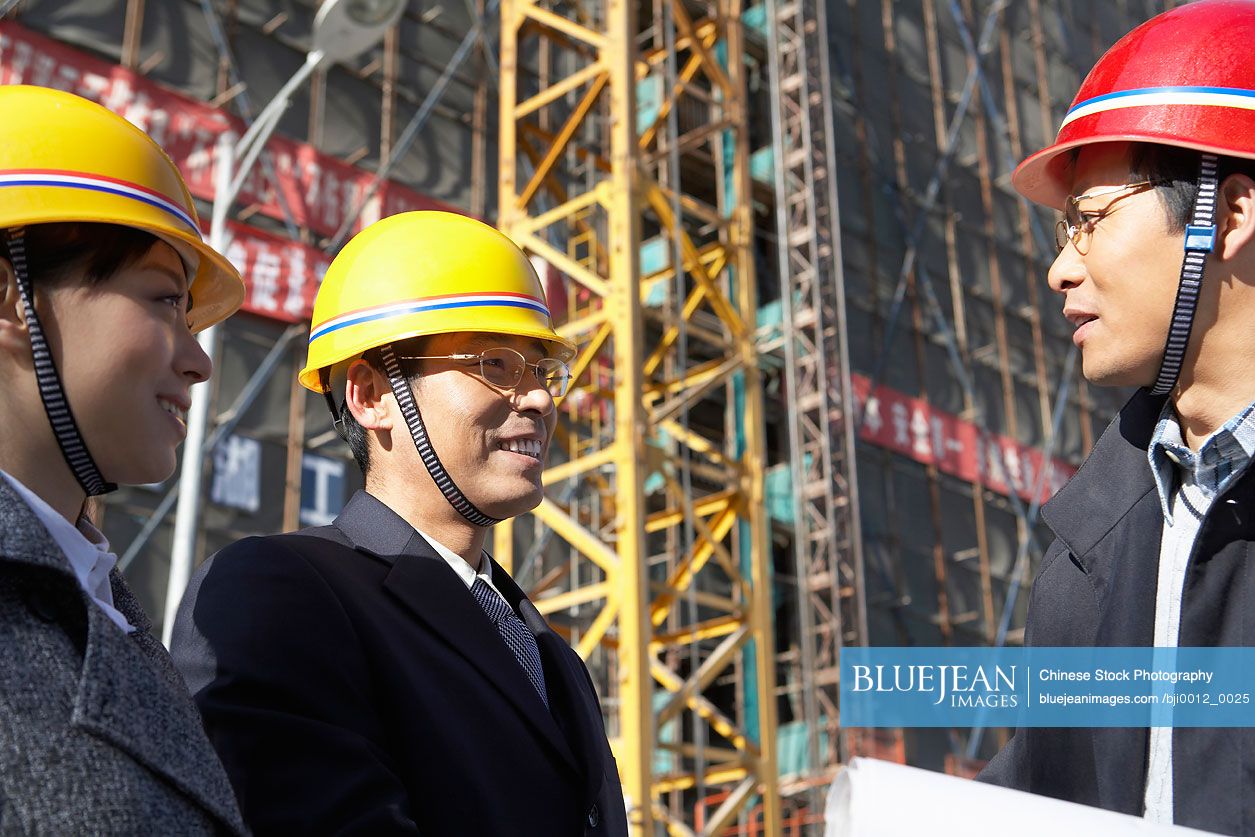 Chinese businesspeople in construction site wearing hard hats-High-res ...