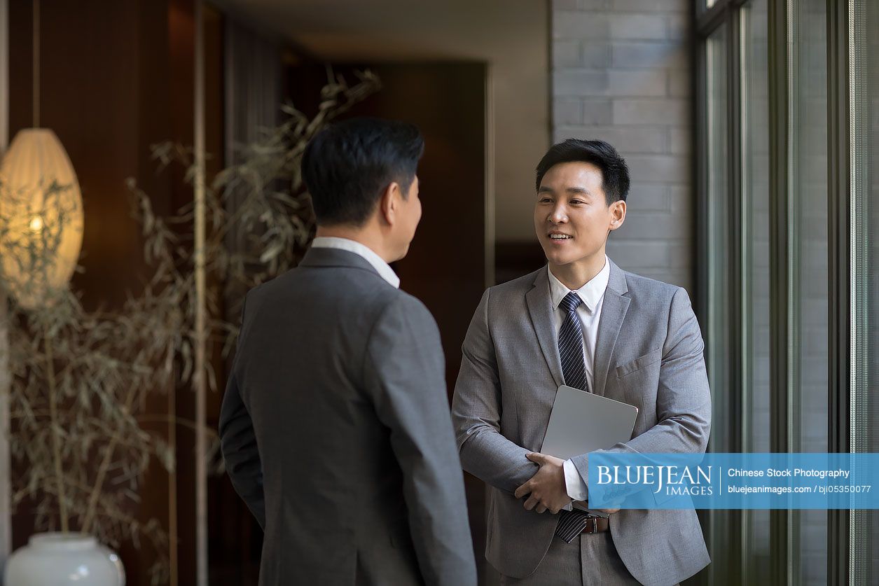 Cheerful Chinese businessmen talking-High-res stock photo for download