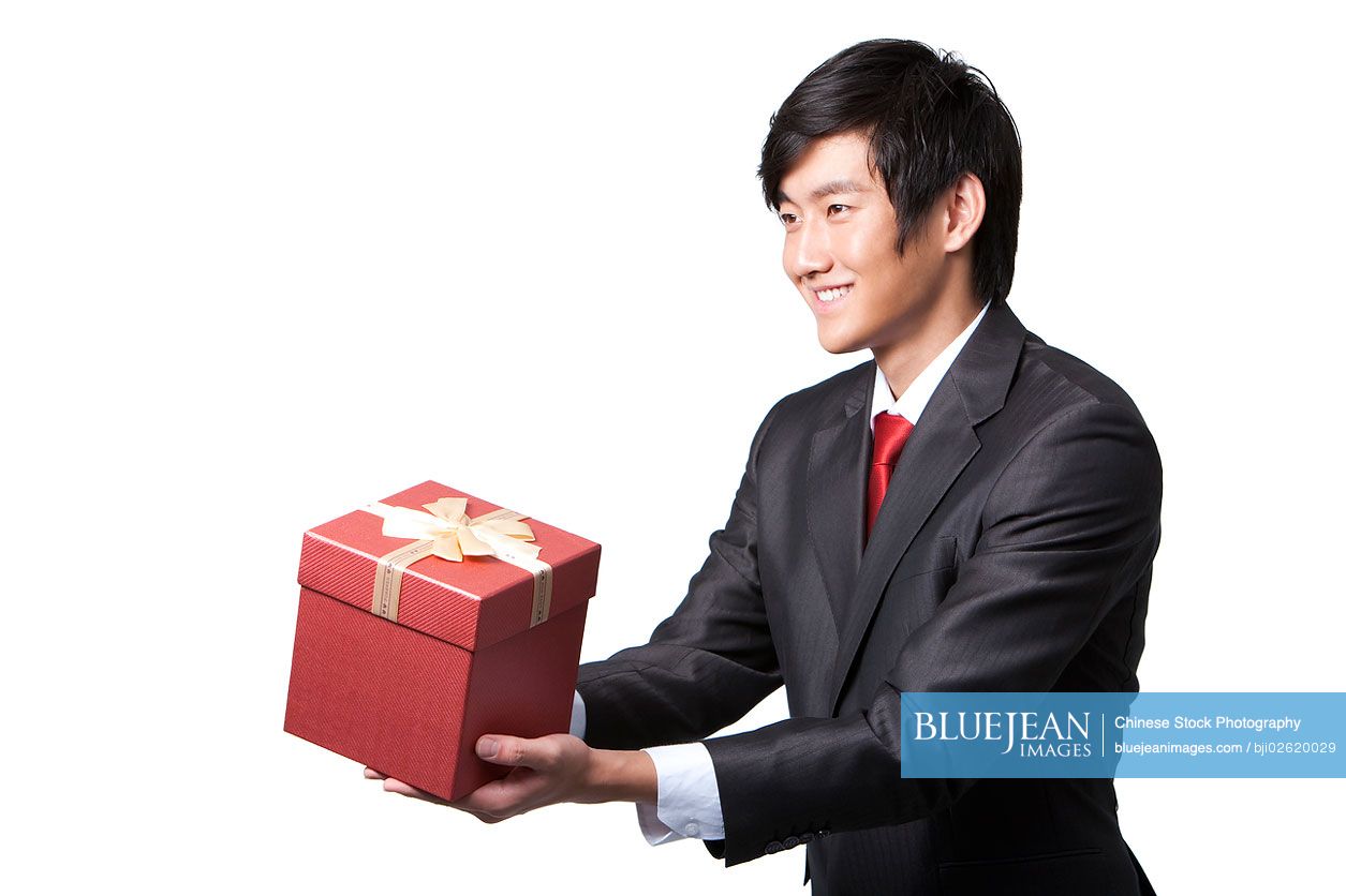 Happy Chinese businessman holding a gift-High-res stock photo for download